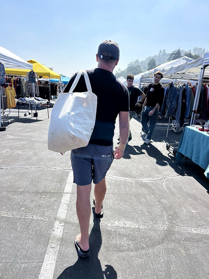 The white tote bag&mdash;unofficial uniform of serious flea market warriors. This gentleman has clearly come prepared for significant discoveries.