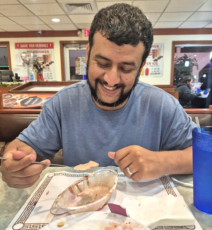 The diner's interior shows a patron enjoying that magical moment when the first bite exceeds all expectations.