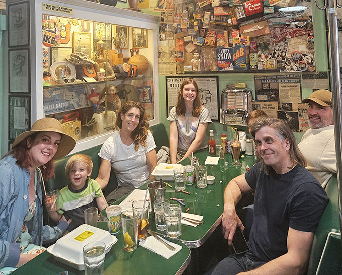 Families gather around mint-green tables, creating new memories in a space dedicated to preserving the old ones.