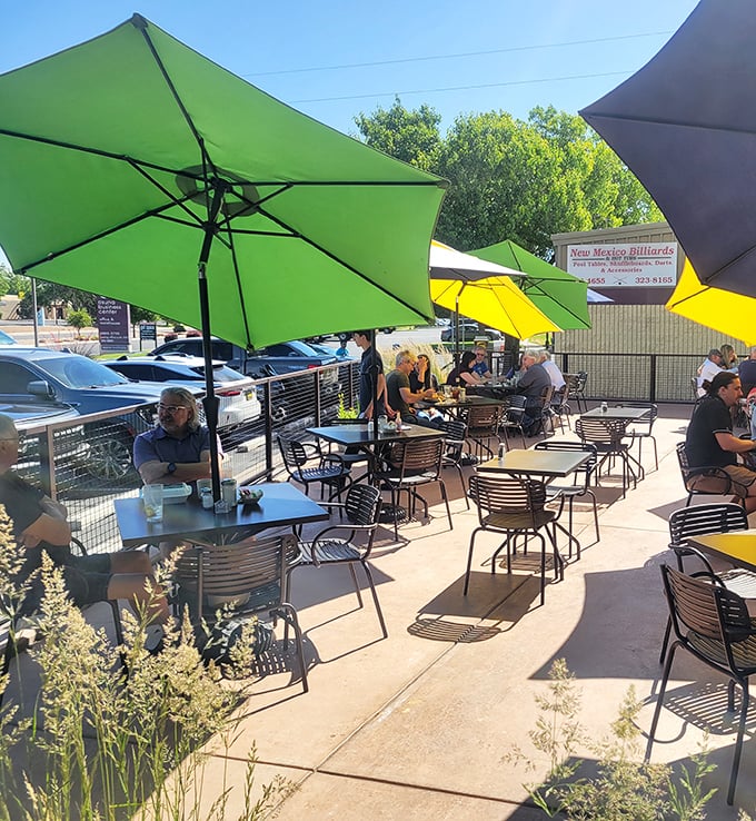 The outdoor seating area offers a sunny escape with colorful umbrellas. Perfect for enjoying breakfast while soaking up some New Mexico sunshine.