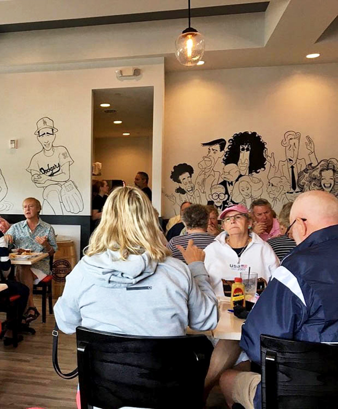 Where locals gather to debate important matters like "pastrami or corned beef?" under the watchful eyes of wall caricatures.