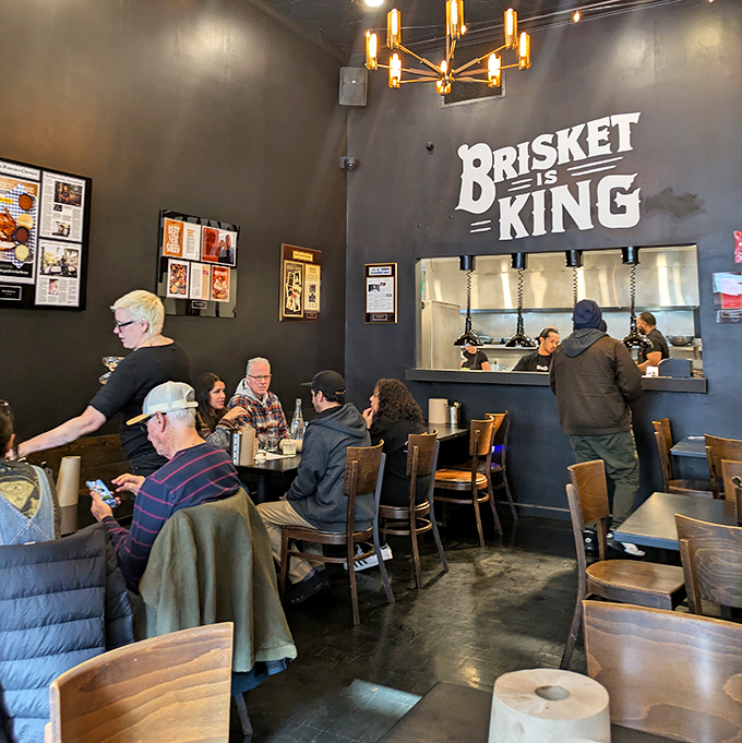 Where strangers become friends over shared barbecue revelations. That "Brisket King" sign watches over its loyal subjects with smoky benevolence.