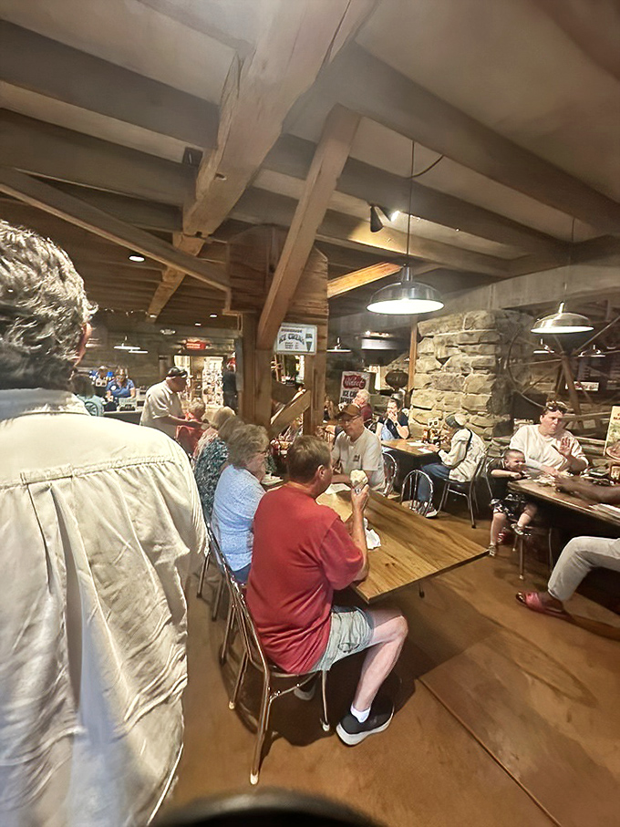 Multi-generational ice cream enthusiasts gather under historic beams, participating in a sweet tradition that spans decades.
