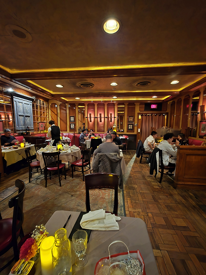 Diners settle into the warm glow of this wood-paneled sanctuary, where conversations flow as freely as the au jus.