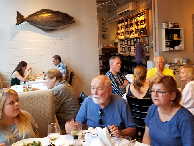 A bustling dining room where strangers become friends, united by their mutual appreciation for exceptional seafood.