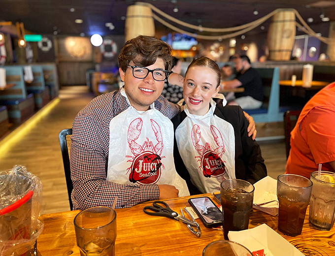 Two happy diners sporting their battle gear&mdash;those bibs aren't just practical, they're badges of honor in the seafood warrior hall of fame.