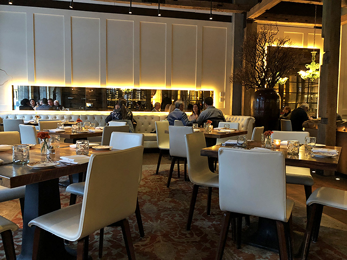 White chairs and warm lighting create the perfect backdrop for memorable meals. This isn't just dining&mdash;it's theater with a delicious finale.