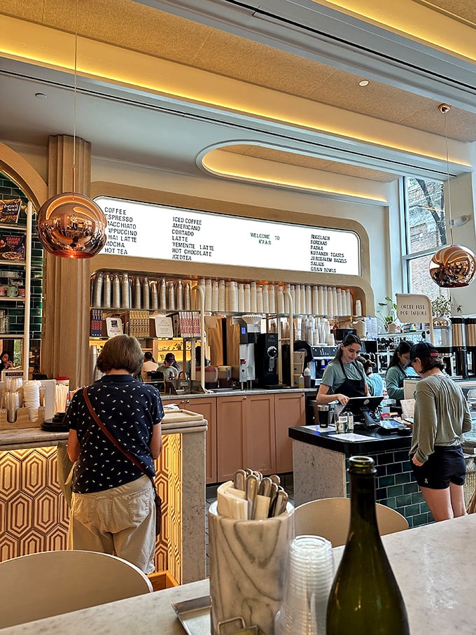 The coffee counter gleams under perfectly positioned lighting, where baristas craft drinks with the precision of scientists and the passion of artists.