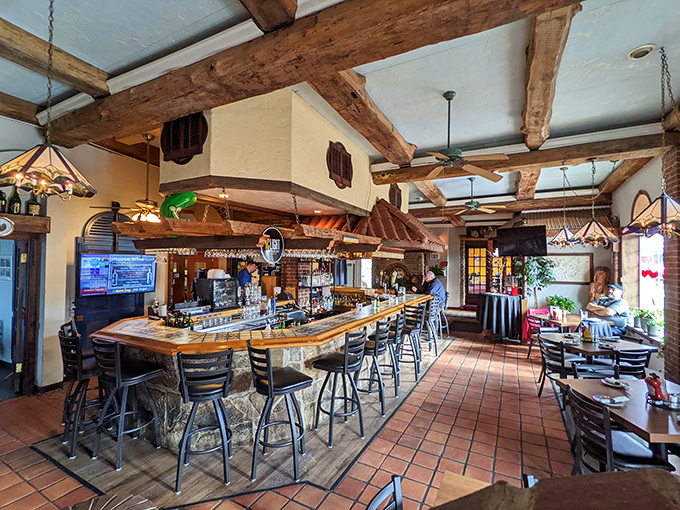 The bar area combines rustic charm with modern comfort, where exposed beams and string lights create the perfect backdrop for evening libations.