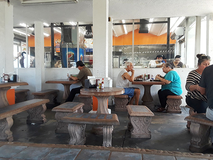 Stone tables and benches create a casual, communal atmosphere where strangers become friends united by their love of exceptional seafood.