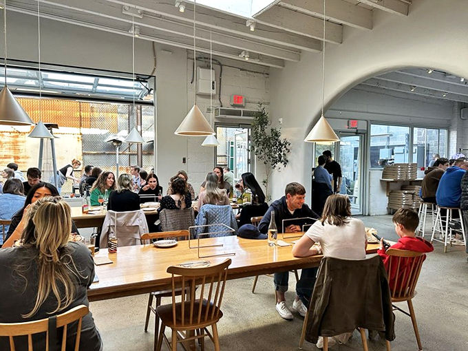 Communal tables where strangers become friends, united by the universal language of exceptional pizza. Food brings people together.