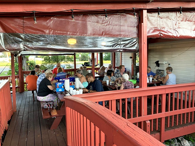 The covered porch becomes a community gathering spot where strangers become friends over shared platters of blue crabs.