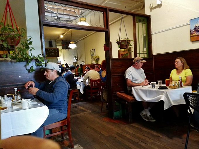 Diners enjoying that perfect moment when conversation pauses because the food deserves your full attention. White tablecloths add a touch of occasion.