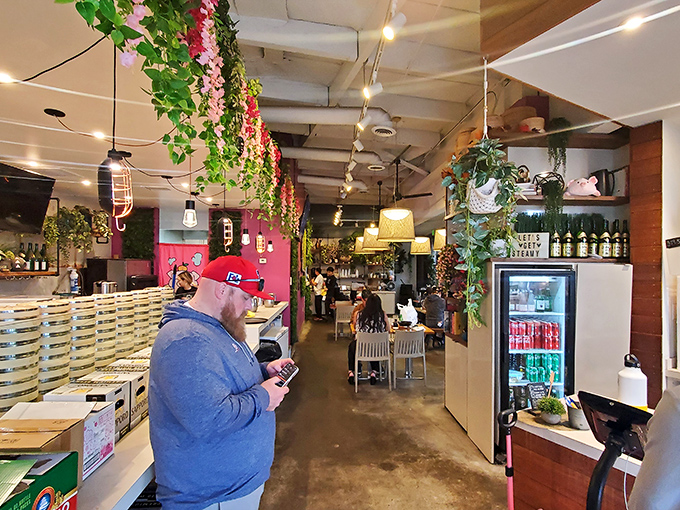 Plants cascading from the ceiling and warm lighting transform a simple meal into an urban oasis experience worth lingering over.