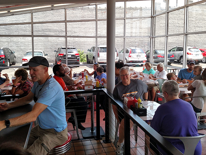 Happy diners filling the sunlit space&mdash;proof that good food creates community faster than any social network.