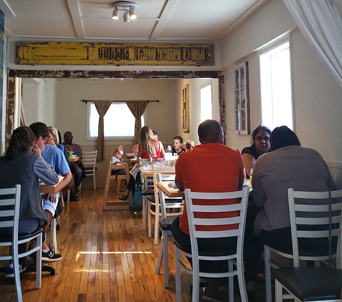 The dining room hums with the satisfied murmurs of breakfast enthusiasts who've found their morning happy place among wooden floors and white chairs.