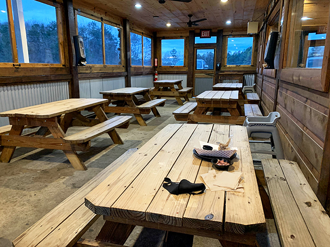 Picnic tables in the covered patio area offer a rustic dining experience where sauce on your shirt is a badge of honor.
