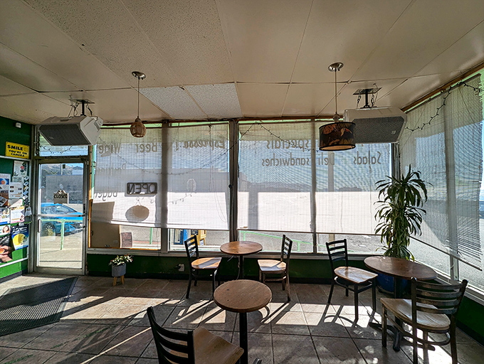 Sun-drenched seating area where the morning light creates shadow plays on simple tables while the ocean provides the day's best entertainment.