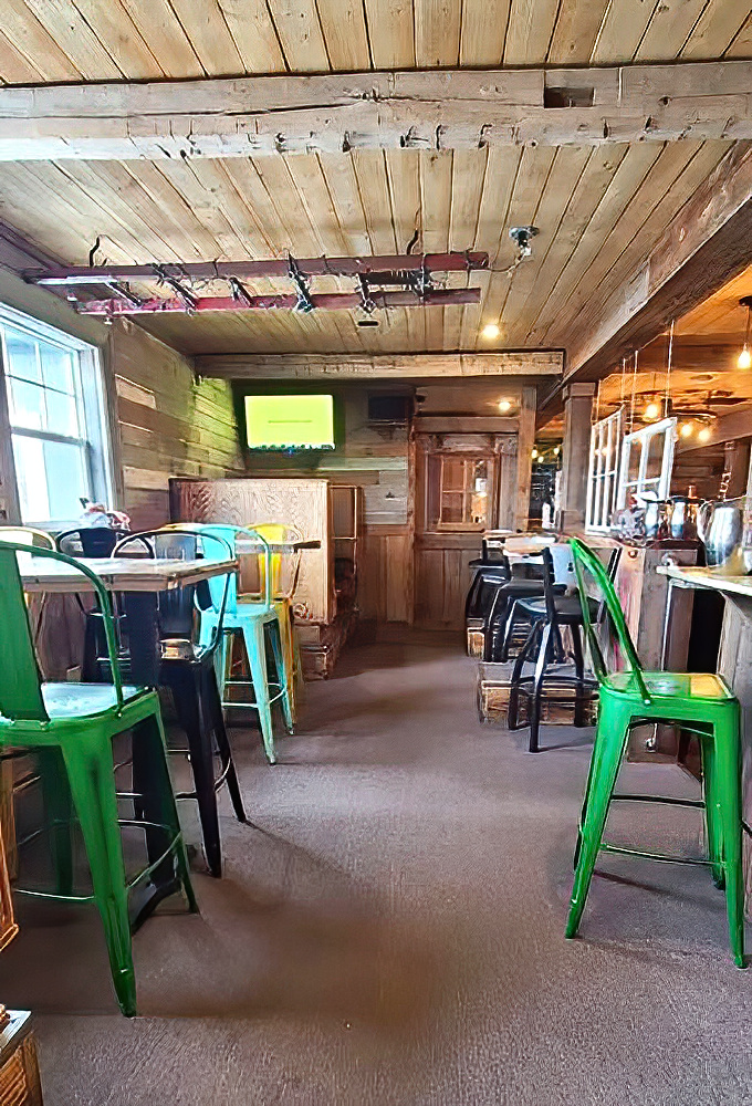 Bright metal chairs pop against wooden walls in this bar area &ndash; like a stylish fishing cabin designed by someone who actually has taste.