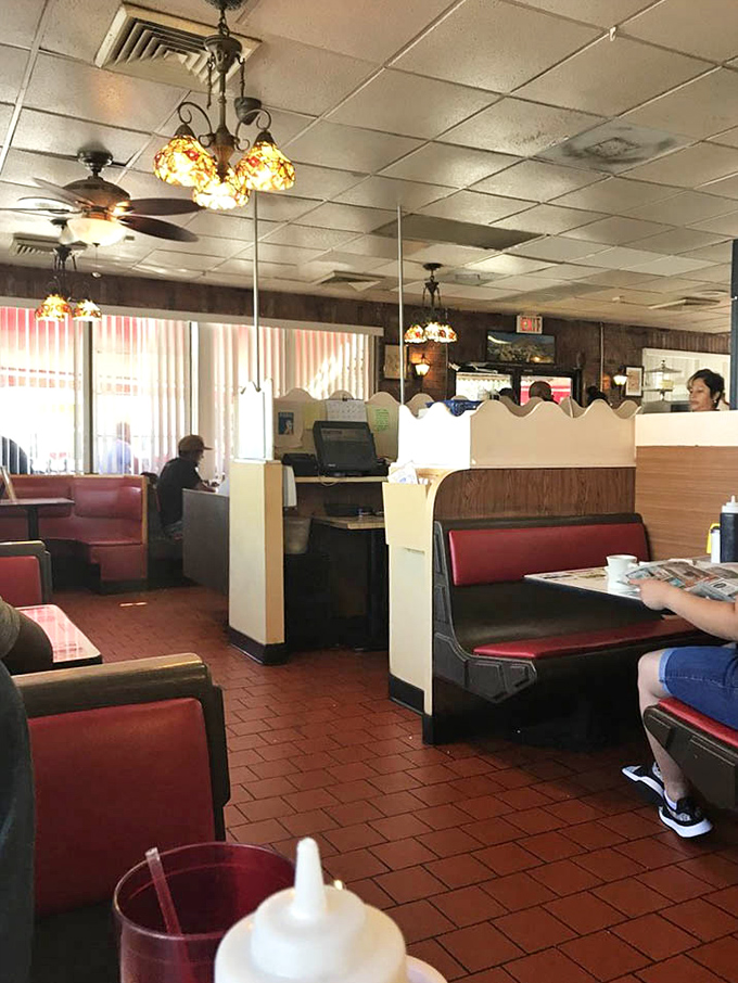 Vintage lighting fixtures casting a warm glow over booths where countless life decisions have been made over coffee refills.
