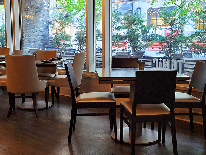 Floor-to-ceiling windows bring the outside in, creating a dining space where urban energy meets culinary tranquility.