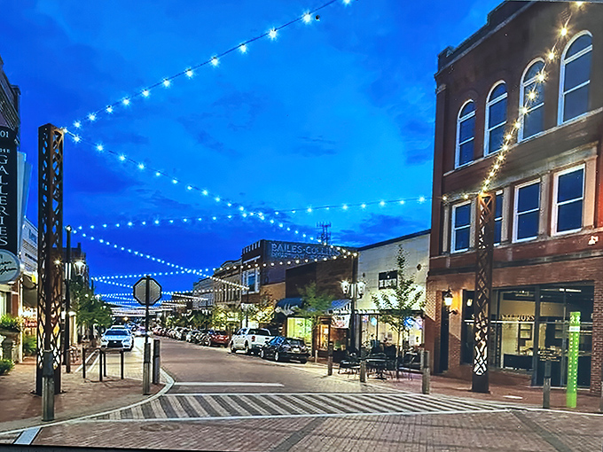 Evening magic transforms downtown with string lights creating an instant atmosphere. Suddenly every dinner feels special when eaten under this canopy of stars and bulbs.