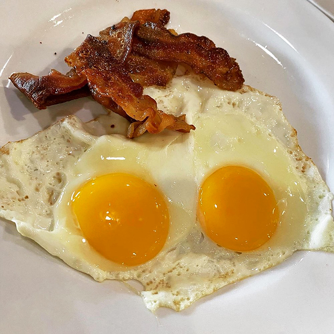 Sunny-side up eggs with that perfect edge crisp and bacon cooked to that ideal point between chewy and crisp. Breakfast fundamentals executed flawlessly.