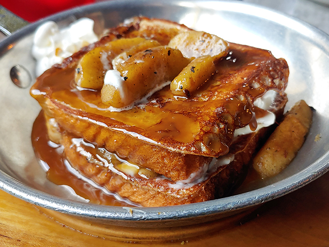French toast that's crossed the line from breakfast to dessert, swimming in caramel and topped with bananas. Diet plans come here to die gloriously.