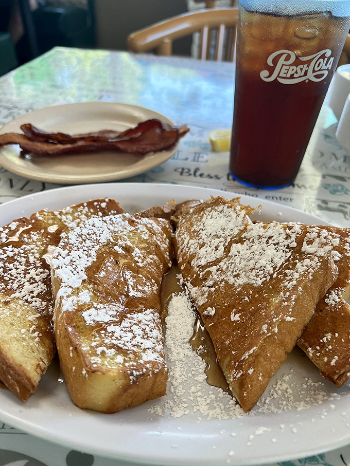 French toast dusted with powdered sugar, served with a side of crispy bacon. The sweet-savory combination that breakfast dreams are made of.