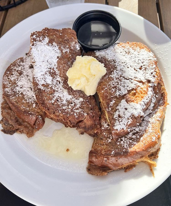 French toast that's achieved the impossible &ndash; crispy edges giving way to a custardy center, all dusted with powdered sugar that melts into buttery pools.