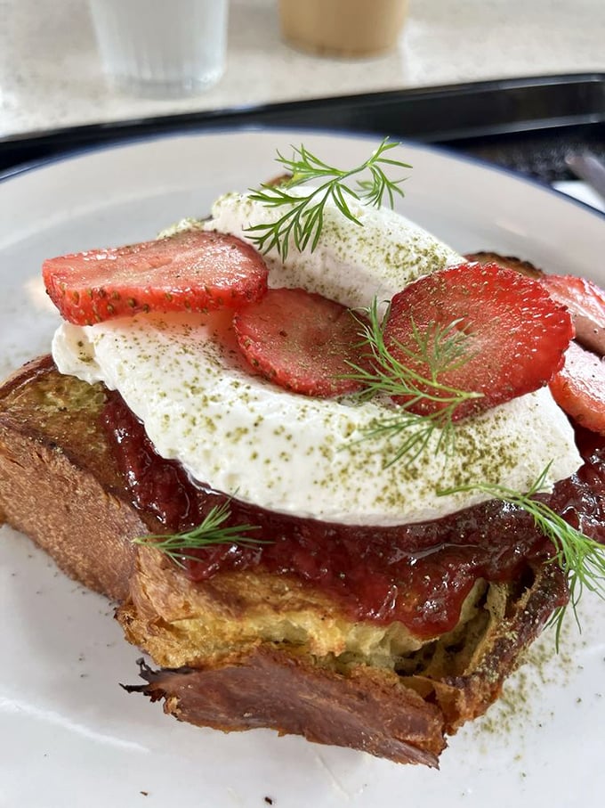 French toast that's dressed better than most people at brunch. Those strawberries and cream are having the time of their lives.