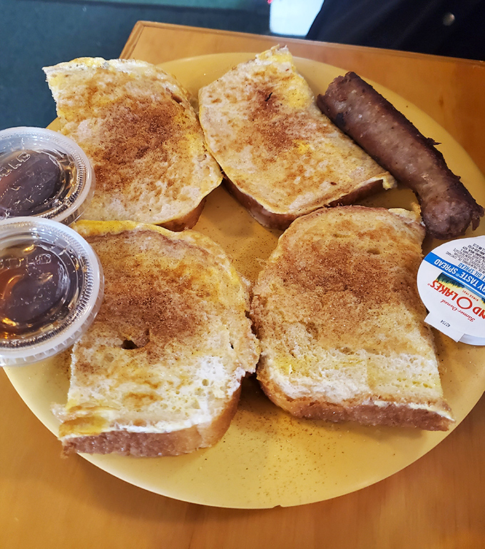 French toast that's achieved the perfect golden-brown exterior while staying pillowy inside. That sausage link is just the bonus round.