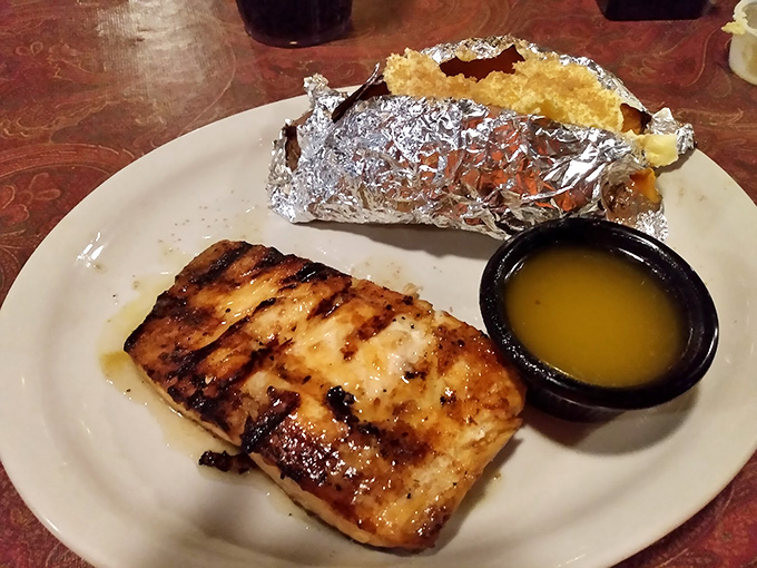 Grilled salmon that flakes at the mere suggestion of your fork, served alongside a baked potato wrapped like a precious gift.