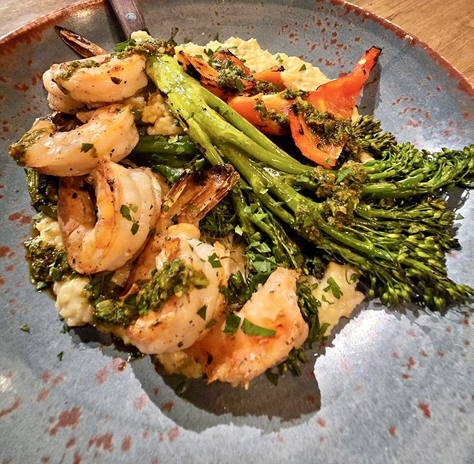 Plump shrimp lounging on creamy polenta with broccolini and peppers&mdash;a plate that feels like a California vacation in the heart of Ohio.