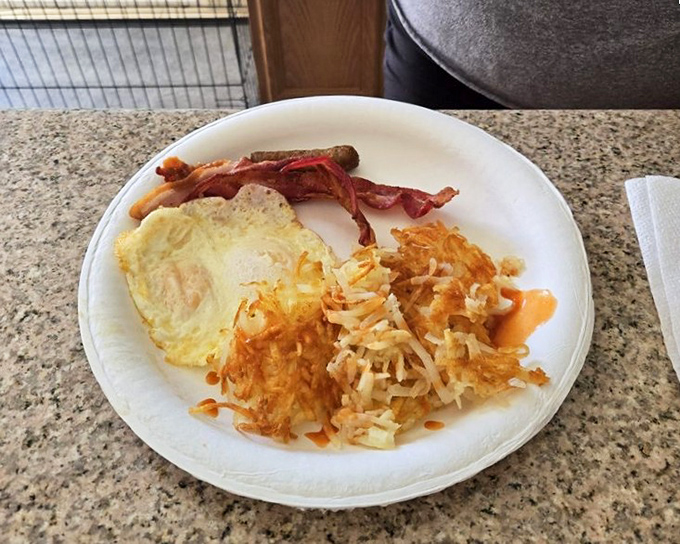 A plate that speaks the universal language of breakfast&mdash;crispy hash browns, sunny-side-up eggs, and bacon that means business.