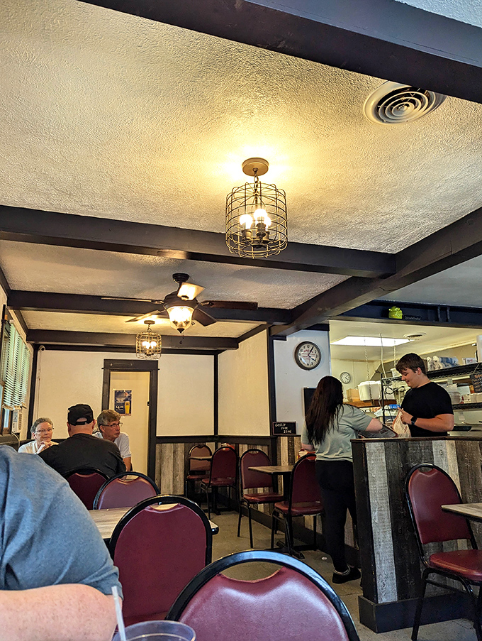 The cage-style light fixtures and exposed beams create an atmosphere that says, "Relax, you're among friends who care more about flavor than fashion."