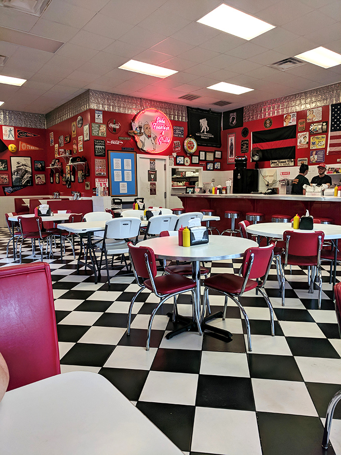 Classic diner geometry: checkerboard floors, chrome-trimmed tables, and red vinyl chairs that have witnessed countless coffee refills and life stories.