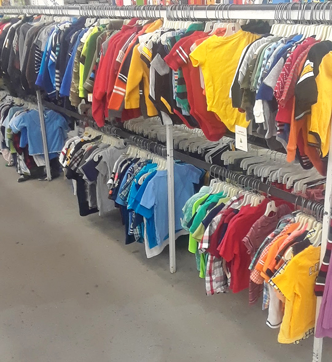 Kids' clothes arranged by color create a cheerful spectrum of tiny fashion. Outgrown but not outworn, these garments await new adventures with fresh explorers.