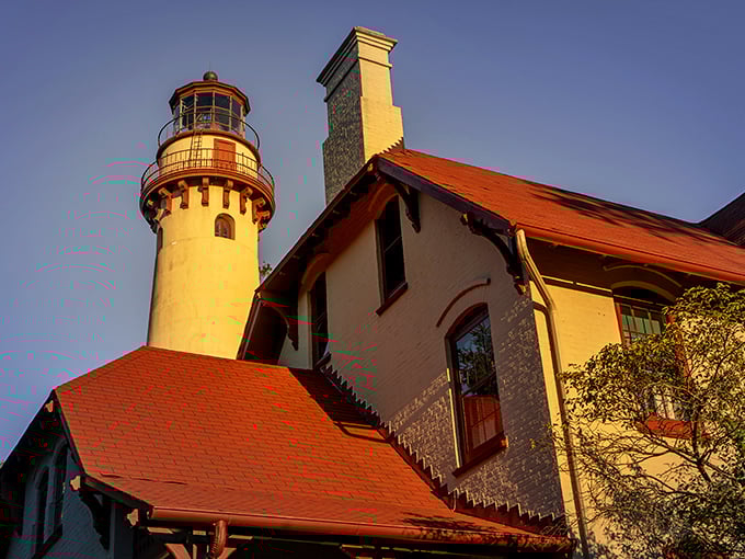 Golden hour bathes the lighthouse in warm light, creating the kind of sunset view that makes amateur photographers feel like professionals.
