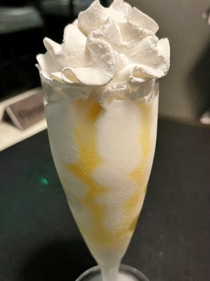 A dessert that looks like clouds decided to vacation in a champagne flute, with caramel streaks for dramatic effect.