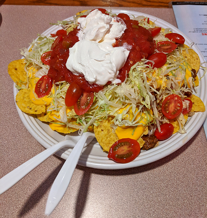 Nachos that require a strategy to eat &ndash; a mountain of chips, cheese, tomatoes, and sour cream that's worth every messy bite.
