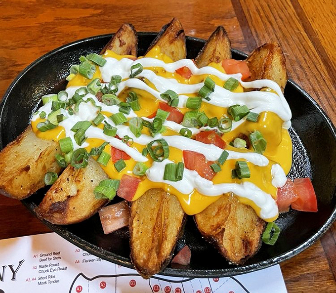 Potato wedges living their best life. Smothered in cheese, sour cream, and green onions&mdash;comfort food that refuses to be ignored.