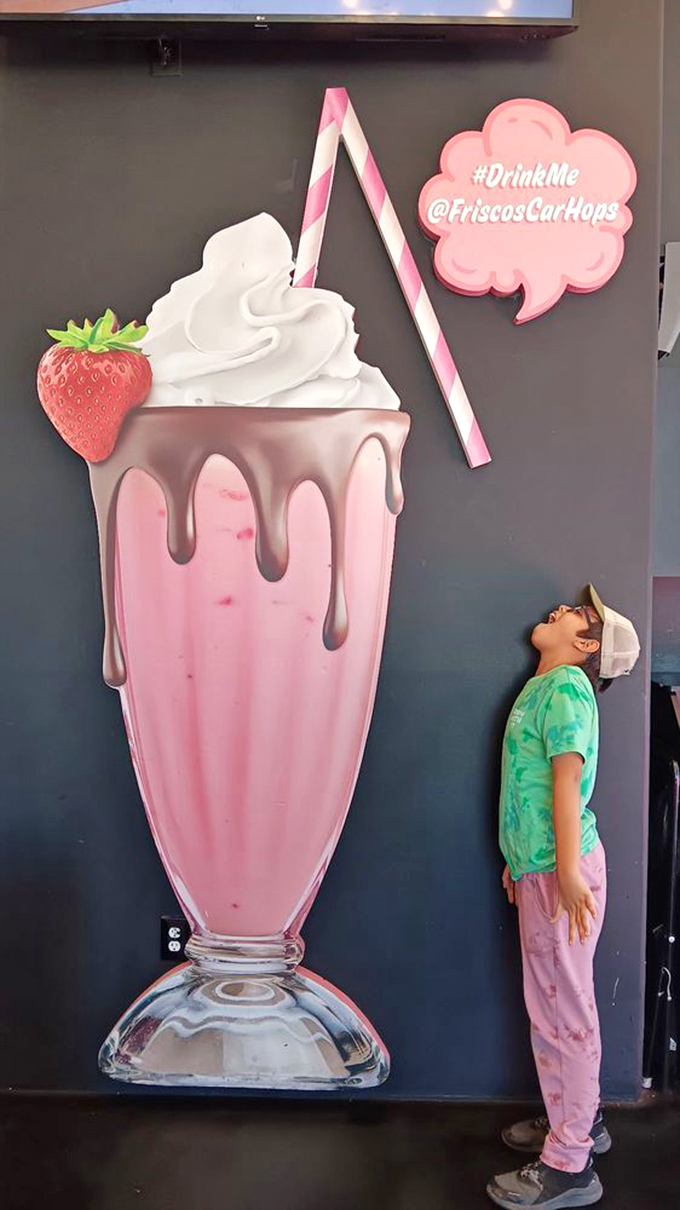 Wall art that captures the essence of milkshake dreams. Even the young customer seems hypnotized by this larger-than-life strawberry fantasy.