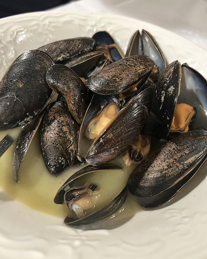 These mussels aren't just opened, they're having a heart-to-heart with white wine sauce that understands them on a deeper level.