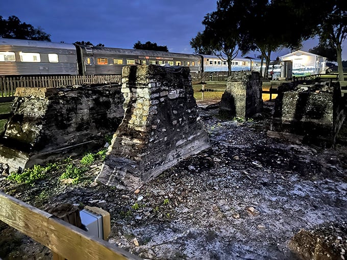 As evening falls, the museum takes on a magical quality, with vintage train cars silhouetted against the twilight sky.