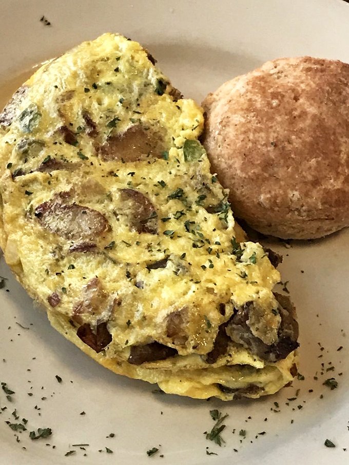 An omelet stuffed with enough fillings to qualify as a small apartment, served with a biscuit that could float away if not weighed down by butter.