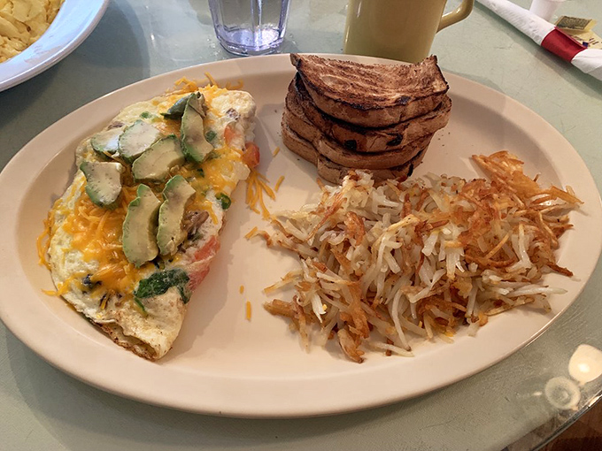 This omelet doesn't just sit on the plate&mdash;it commands attention with avocado slices standing guard like green sentinels of flavor.