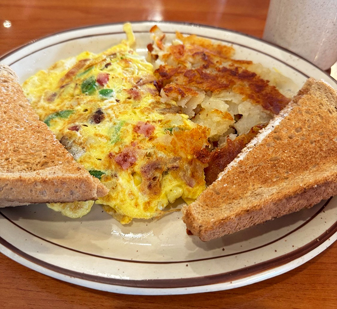 This isn't just an omelet &ndash; it's a morning masterpiece. Packed with ham and veggies, flanked by perfectly toasted bread, it's breakfast that means business.