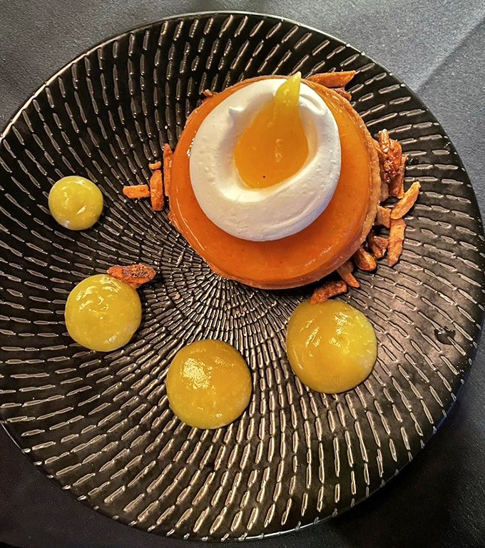 A dessert that belongs in an art gallery. This orange tart with its perfect dollop of cream and golden accents proves that geometry can be delicious.