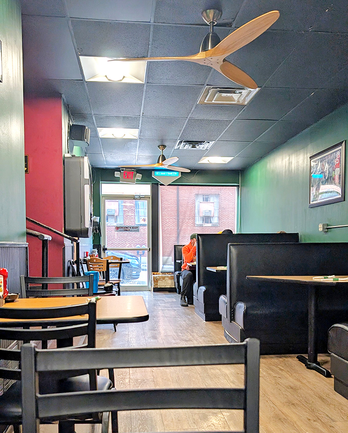 The cozy booth section, where burgundy walls and wooden accents create the perfect backdrop for solving the world's problems over pancakes.